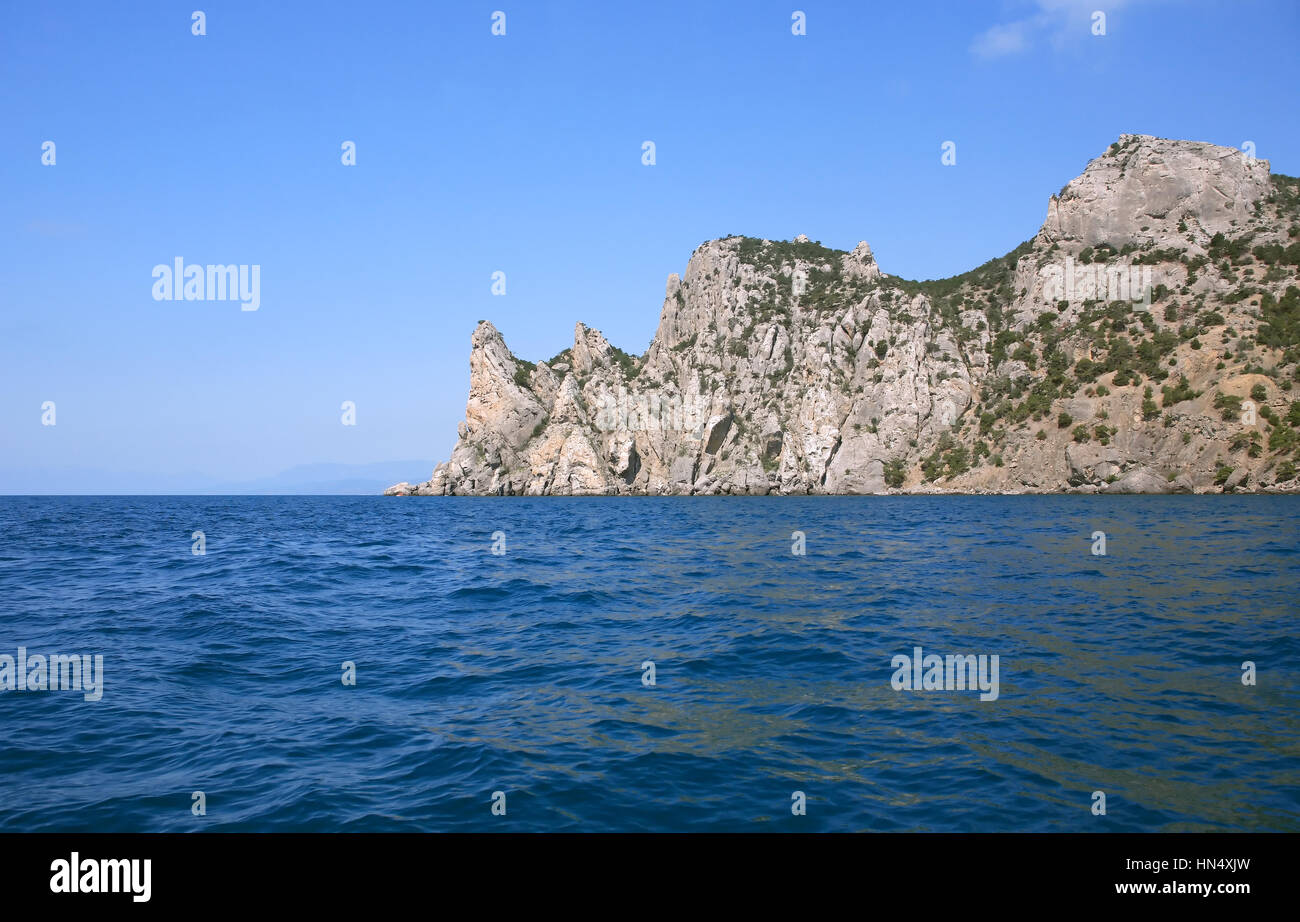Nice humpbacked mountain in the sea against blue sky Stock Photo - Alamy