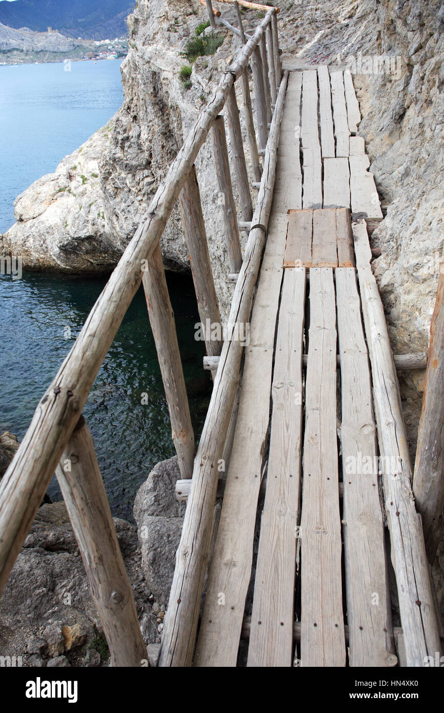 Long wooden bridge between rock and sea Stock Photo - Alamy