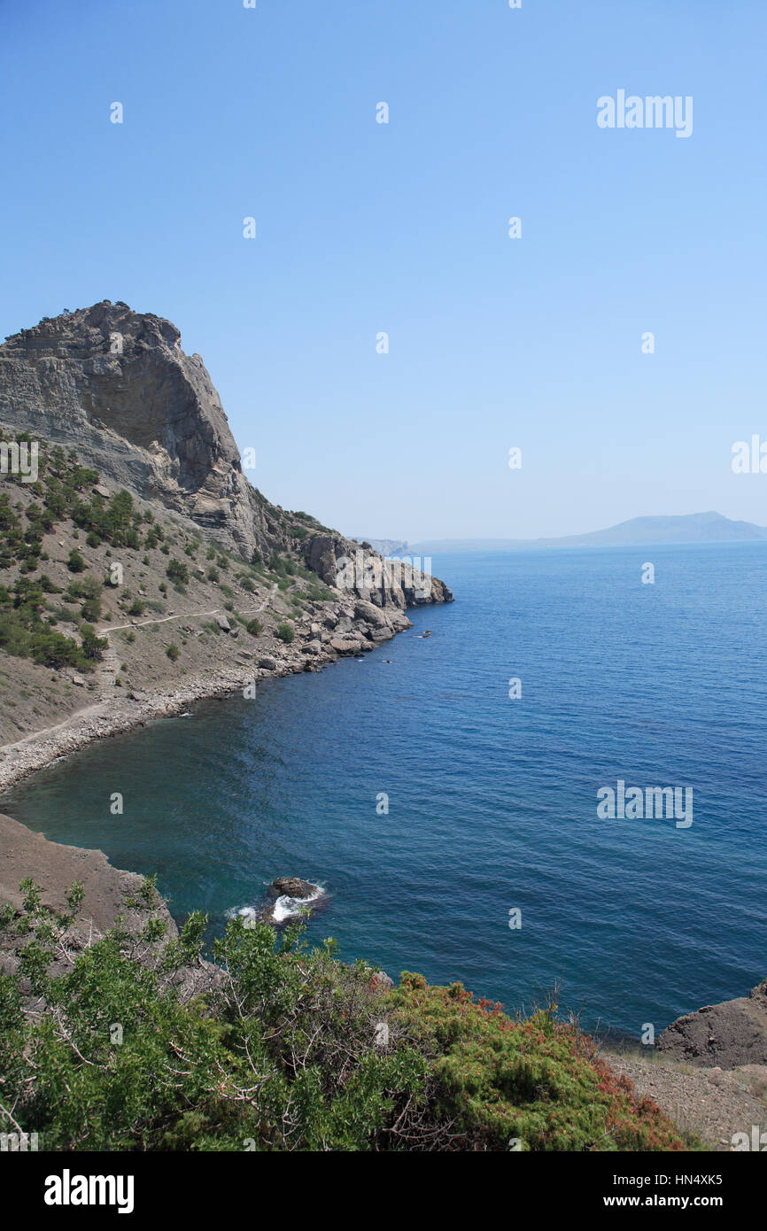 Nice bay with long stone coastline under blue sky Stock Photo - Alamy