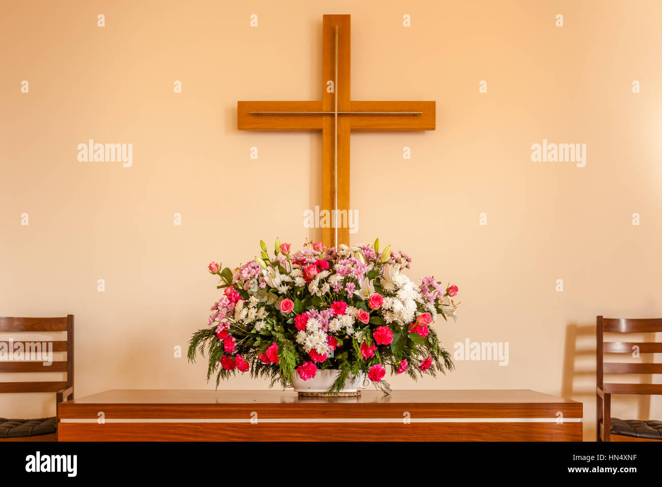 Christian cross, altar, candle and flower bouquet in a church chapel ...