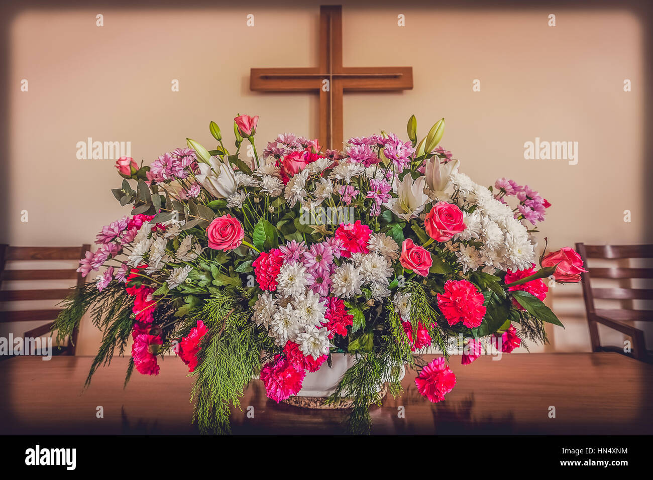 Christian cross, altar, candle and flower bouquet in a church chapel ...