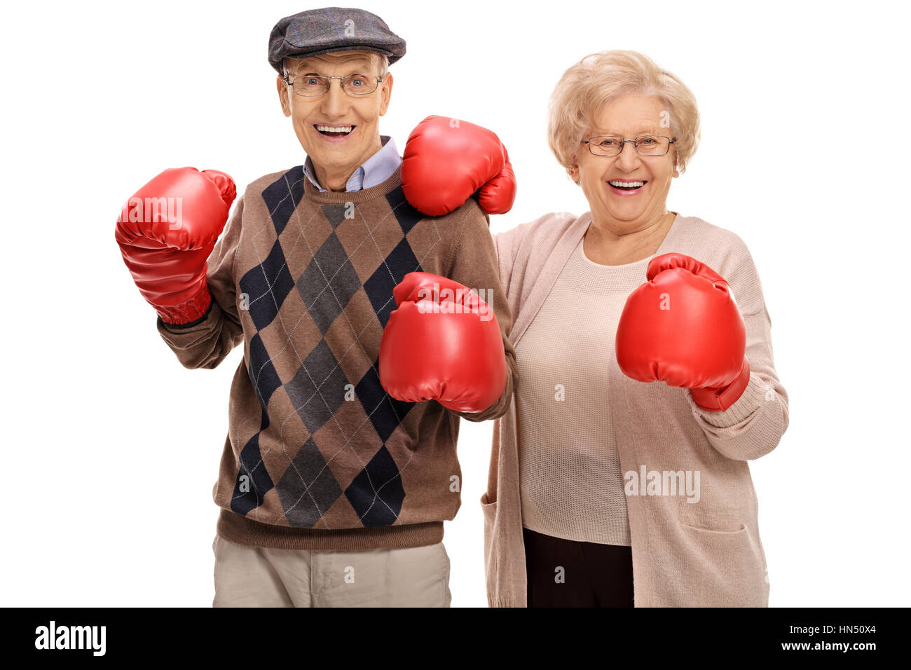 Joyful seniors posing with boxing gloves isolated on white background ...
