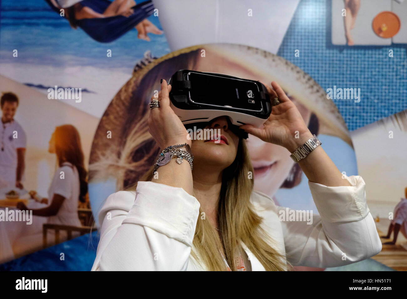 A woman watches tourist content through virtual reality VR goggles for ...
