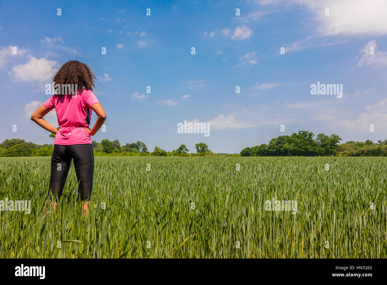 Rear view of young woman girl female runner jogger hands on hips ...
