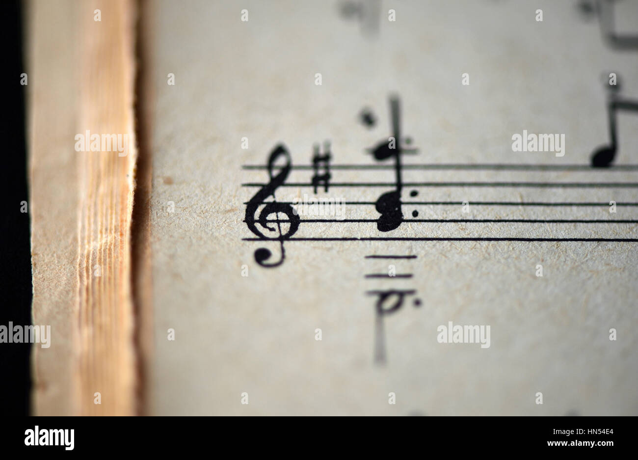 Treble clef and musical notes in the old musical notebook close up ...