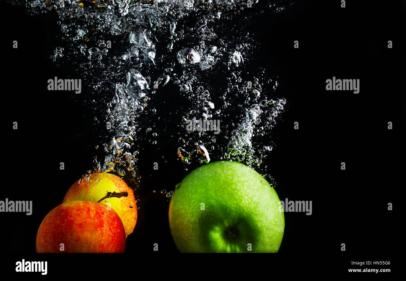 Apples falling into the water with a splash and air bubbles. Healthy ...