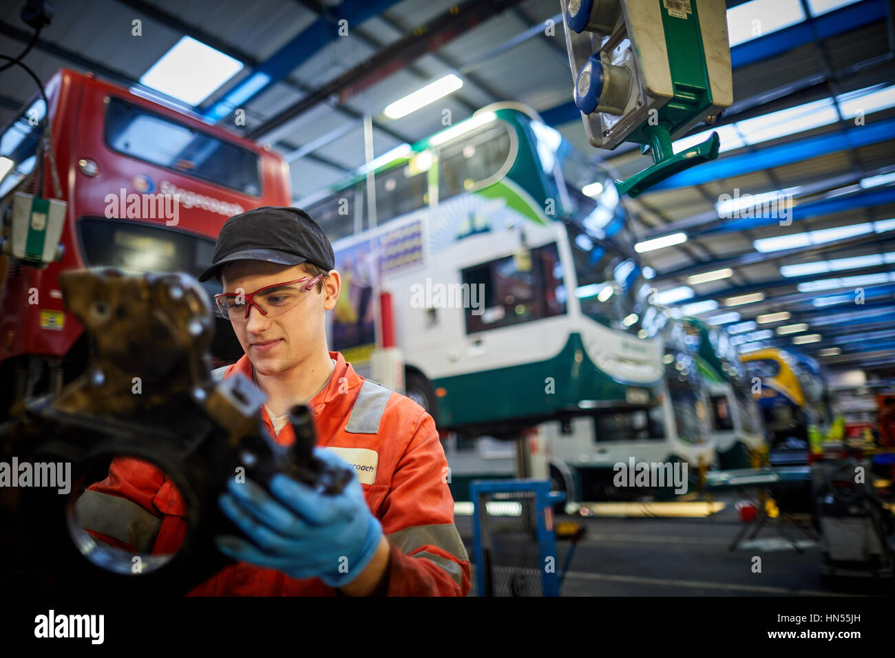 A young teenage apprentice fitter mechanic fixing broken down double ...