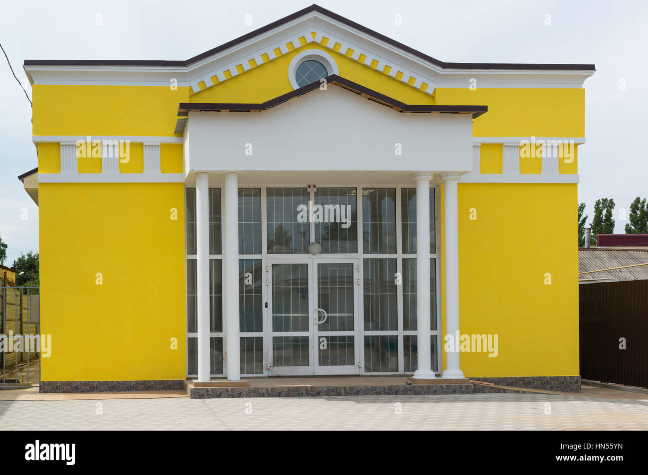 An Yellow administrative office building with glass doors Stock Photo ...