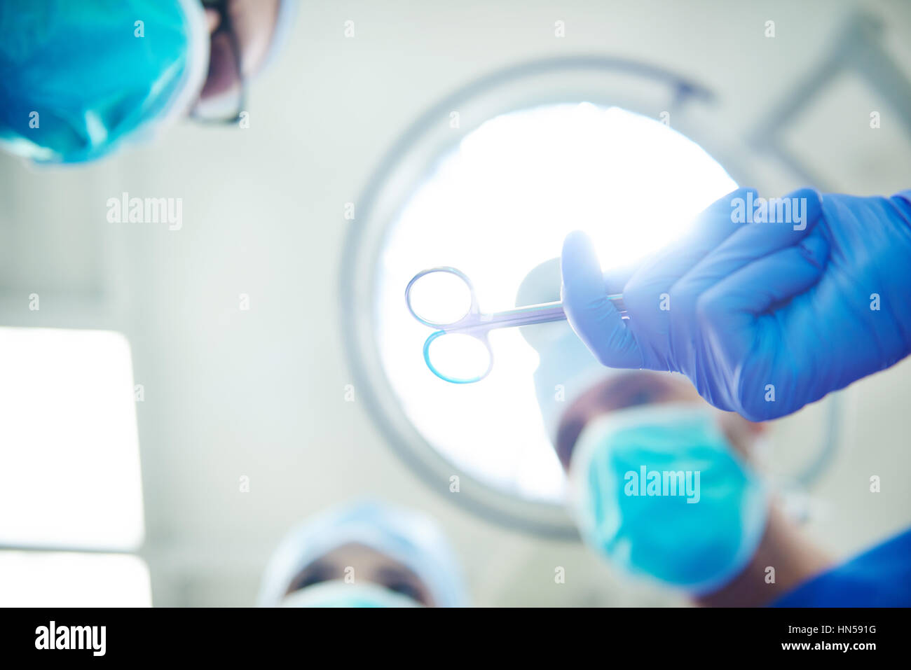Assistant passing surgical scissors to the doctor Stock Photo - Alamy
