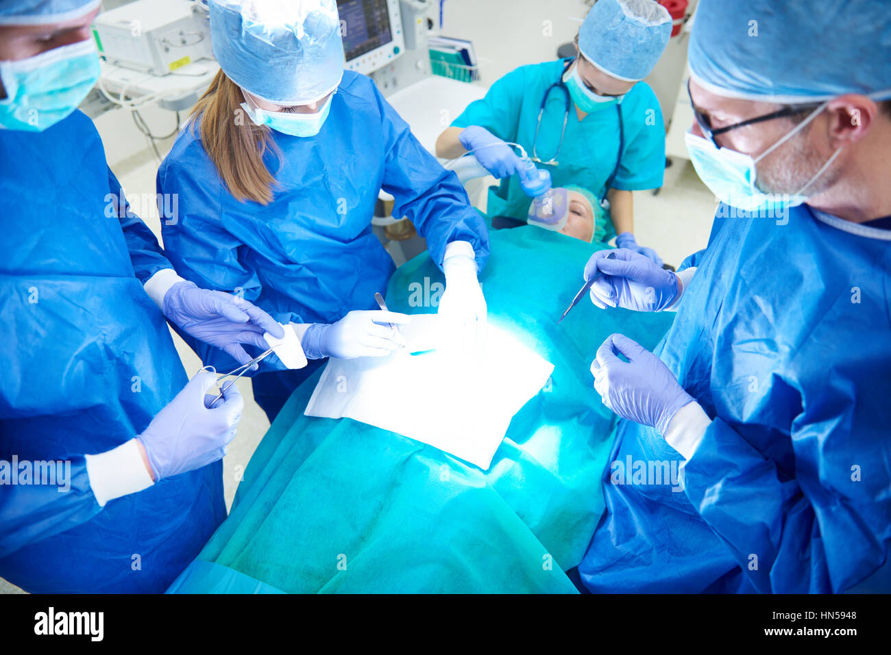 Team of busy surgeons performing an operation Stock Photo - Alamy