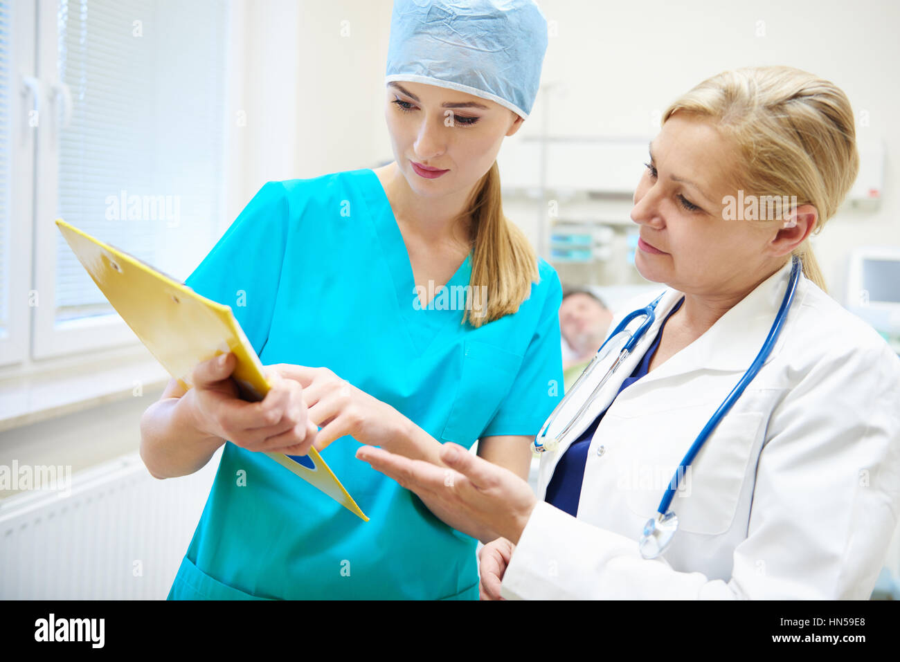 Female doctors discussing some medical records Stock Photo - Alamy
