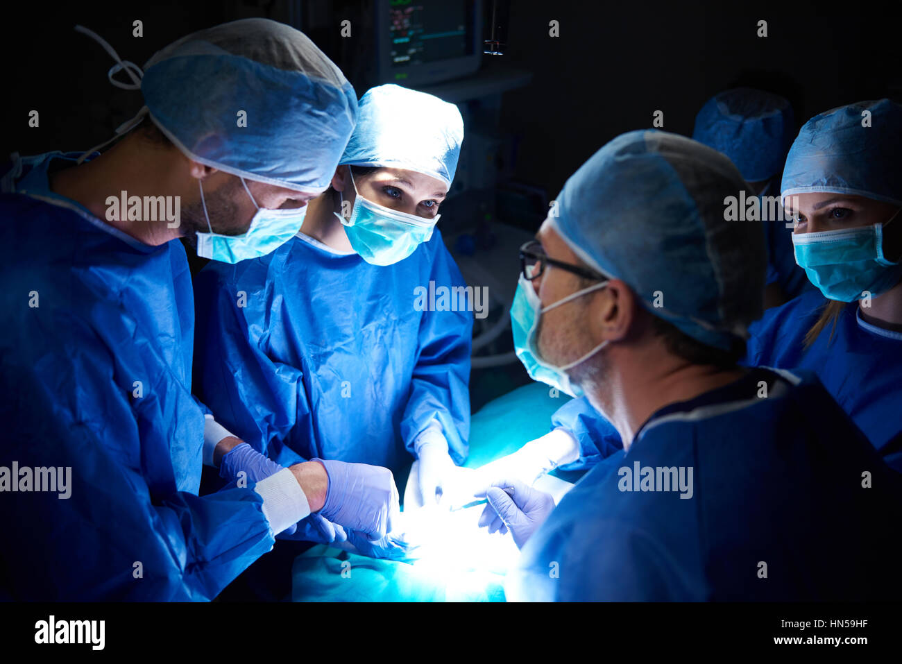 Team of surgeons in the dark operating room Stock Photo - Alamy