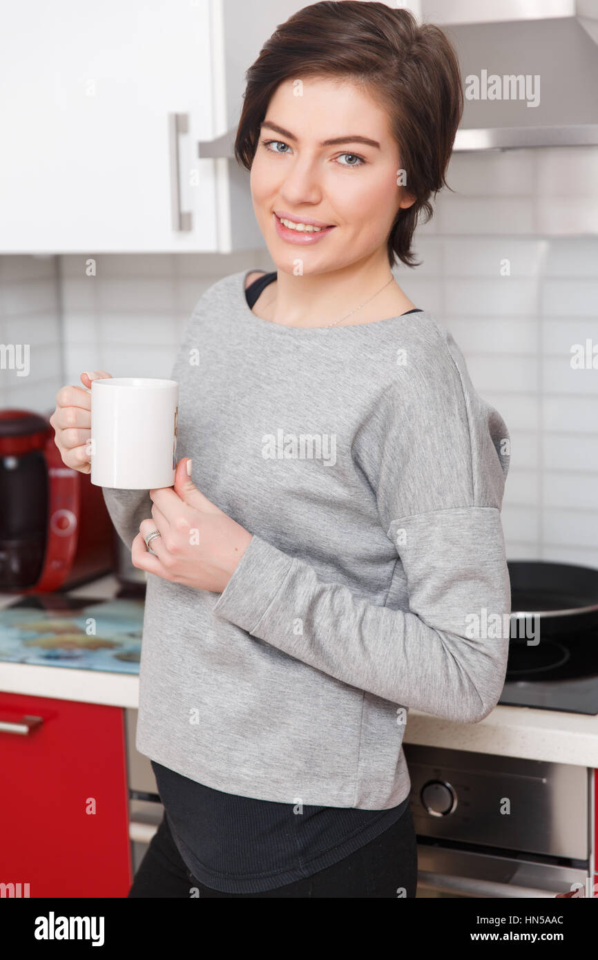 Girl with cup in kitchen Stock Photo - Alamy