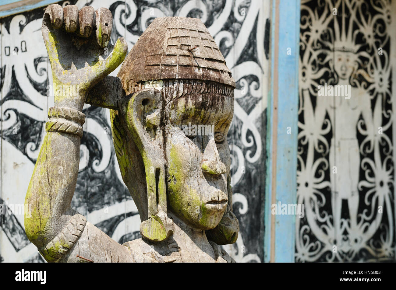 Traditional Dayak tribal culture. Totem in front of Dayak house - long ...