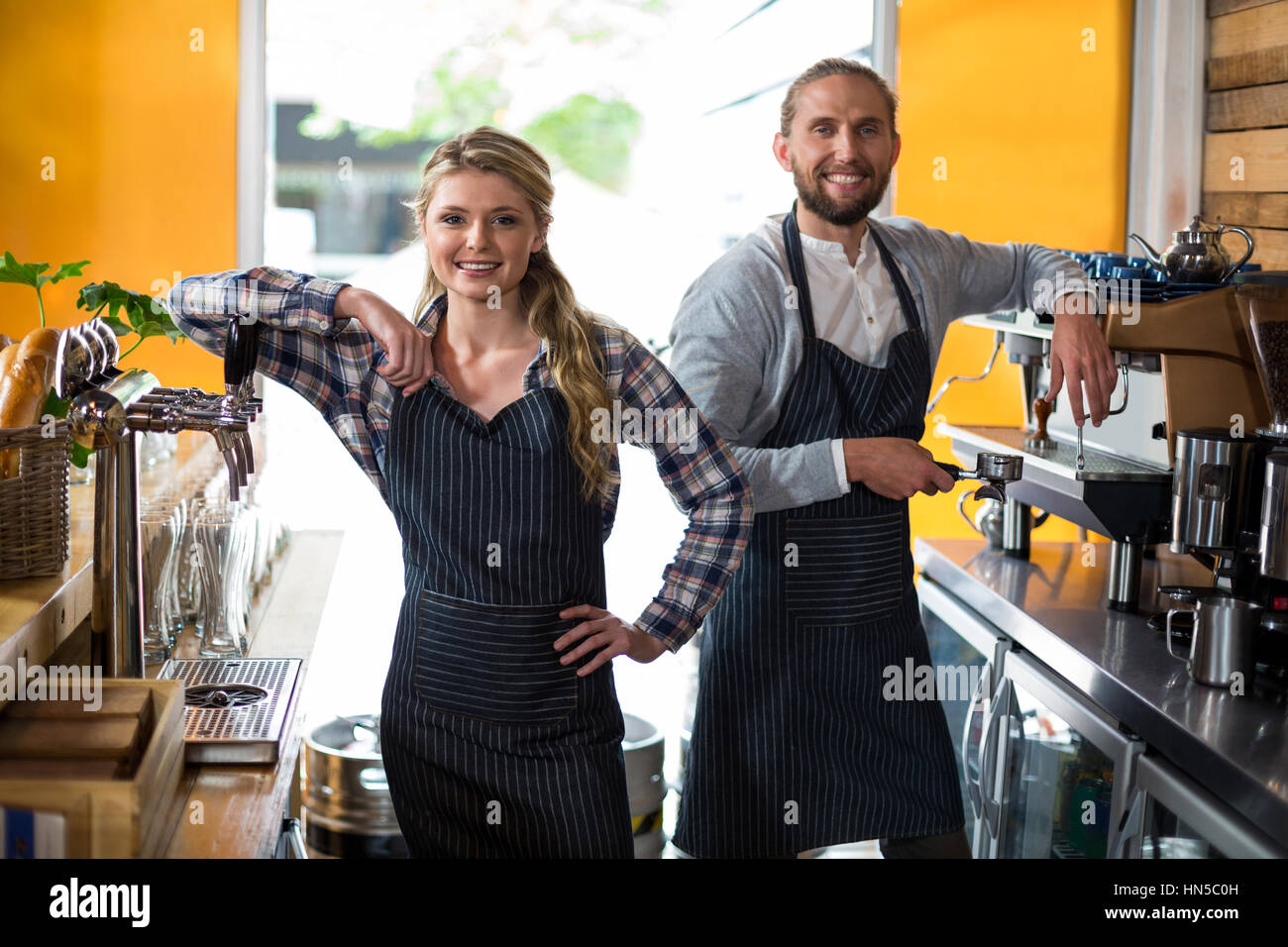 Portrait of smiling waitress and waiter working at counter in cafÃƒÂ ...
