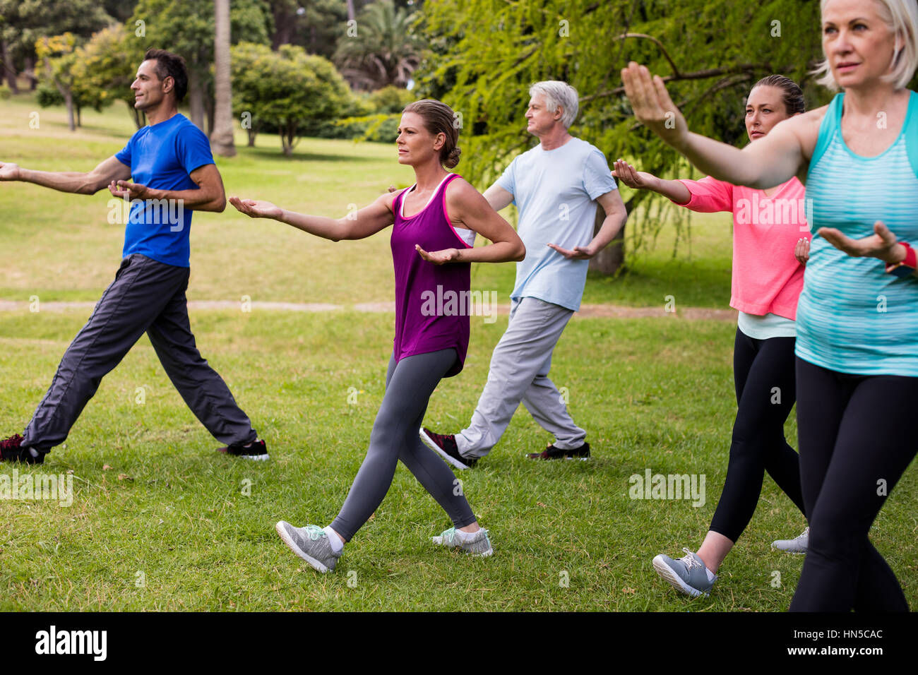 Group of people exercising together in park Stock Photo - Alamy