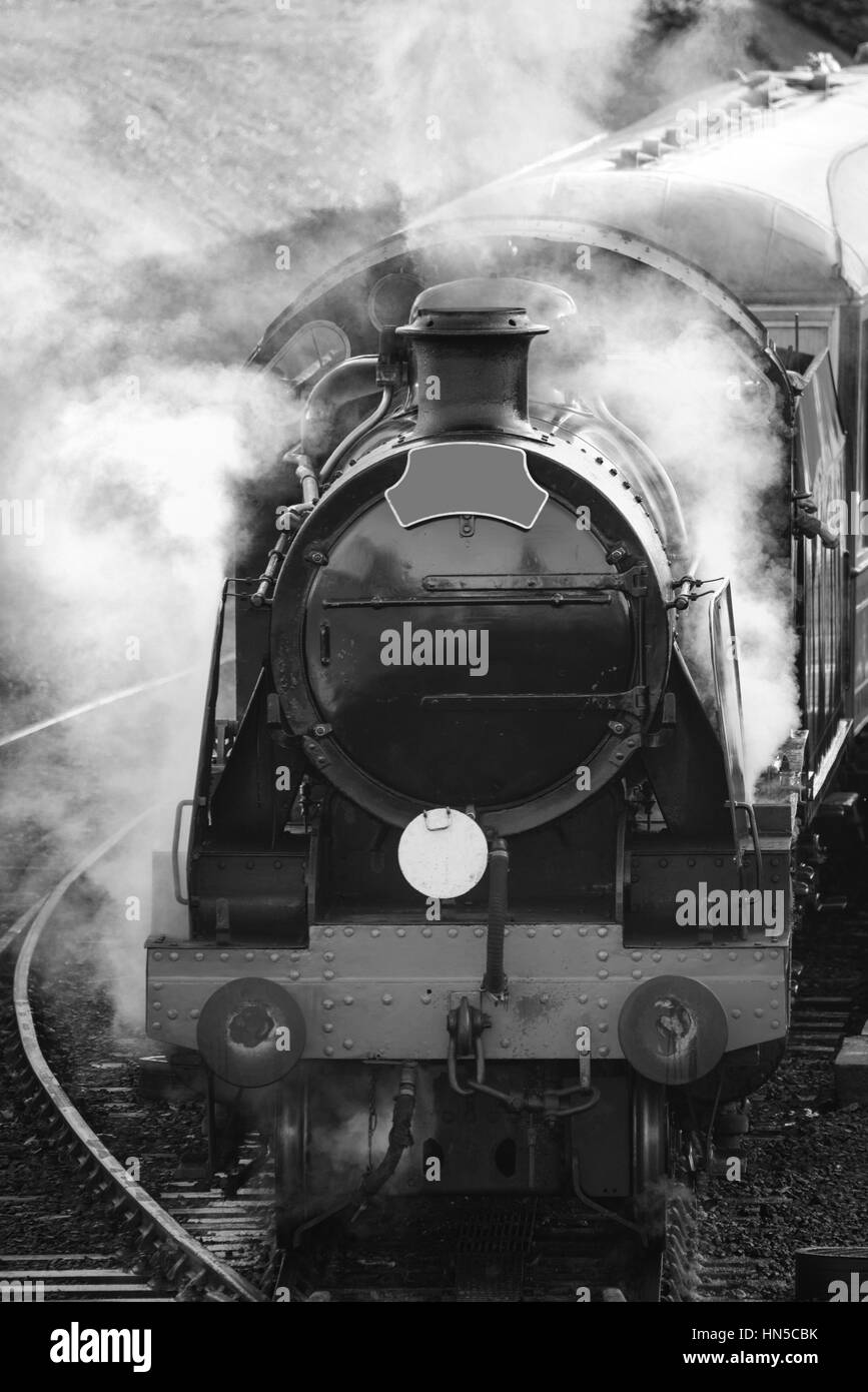 Victorian era steam train engine with full steam in black and white ...