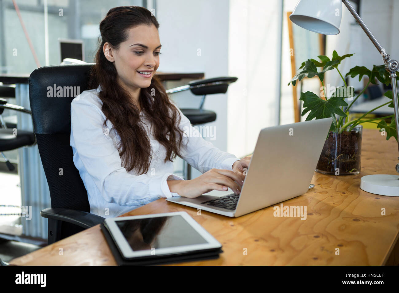 Female business executive using laptop in office Stock Photo - Alamy