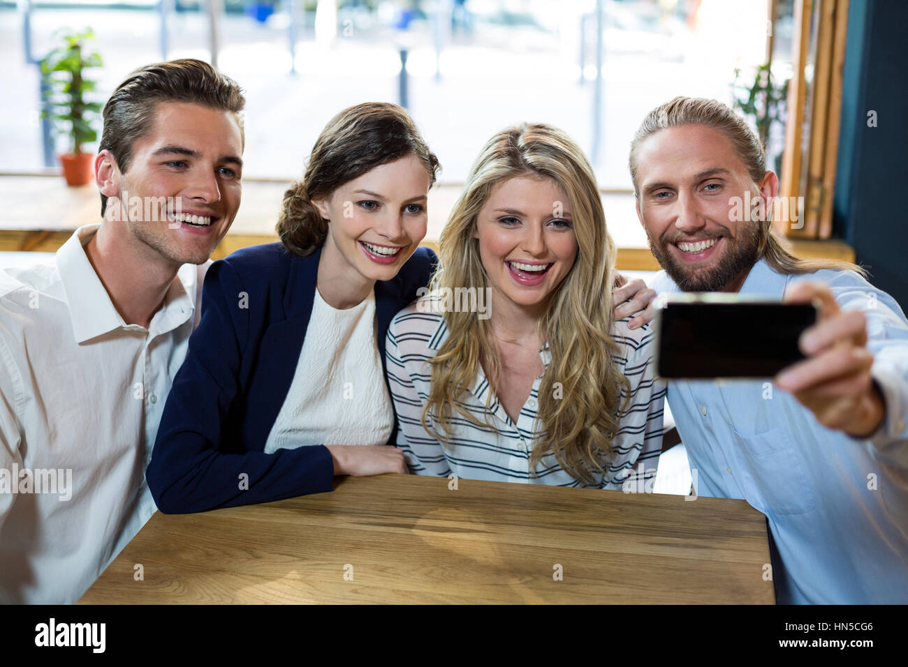 Happy friends taking selfie from mobile phone in cafÃƒÂ© Stock Photo ...