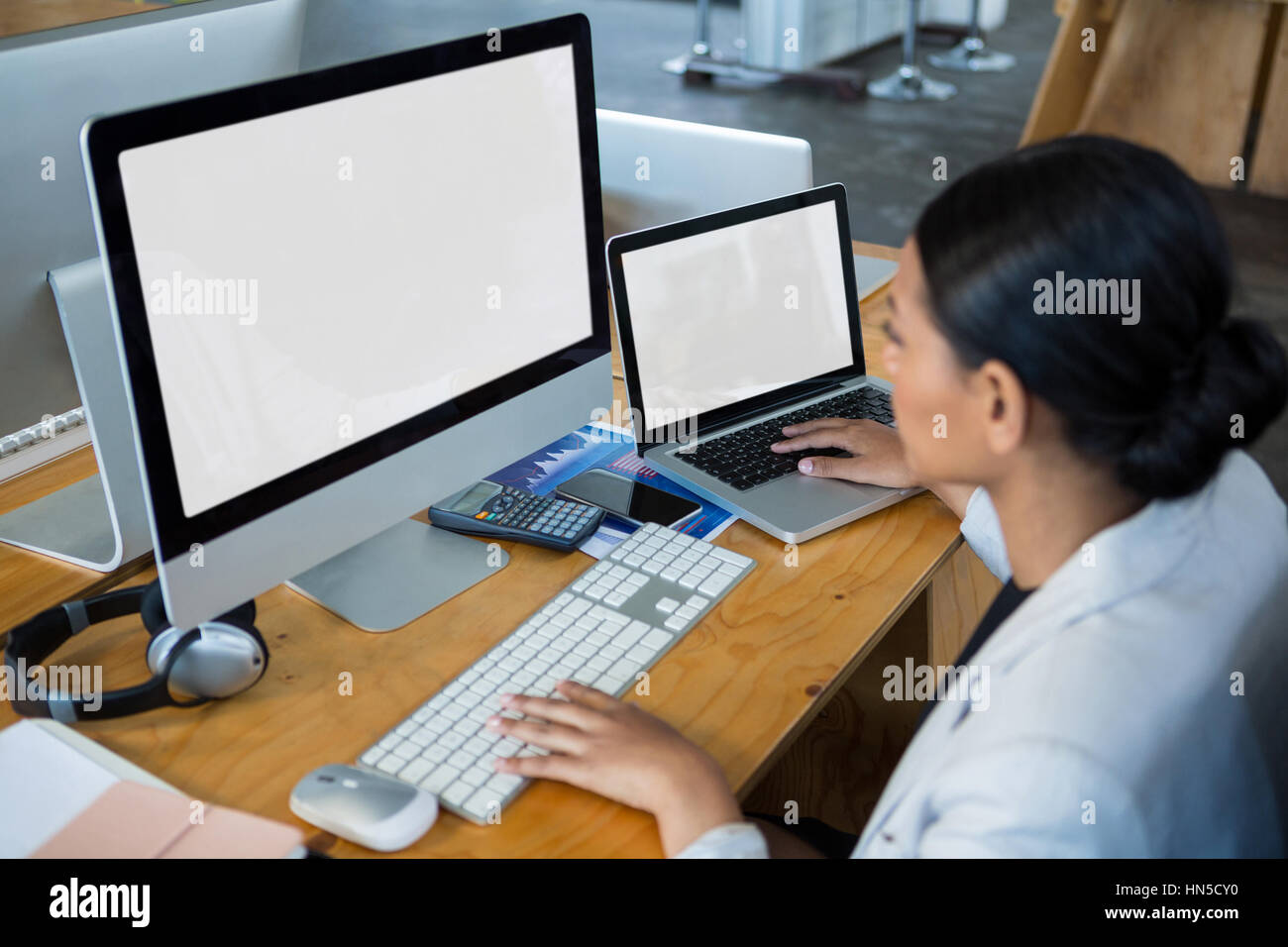 Businesswoman working over computer and laptop in office Stock Photo ...