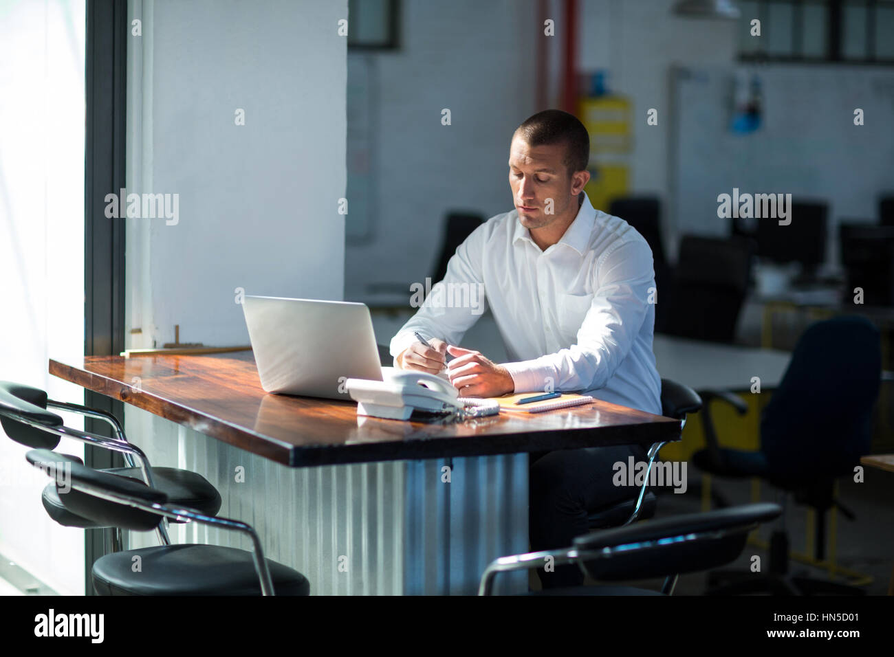 Attentive businessman working at desk in office Stock Photo - Alamy