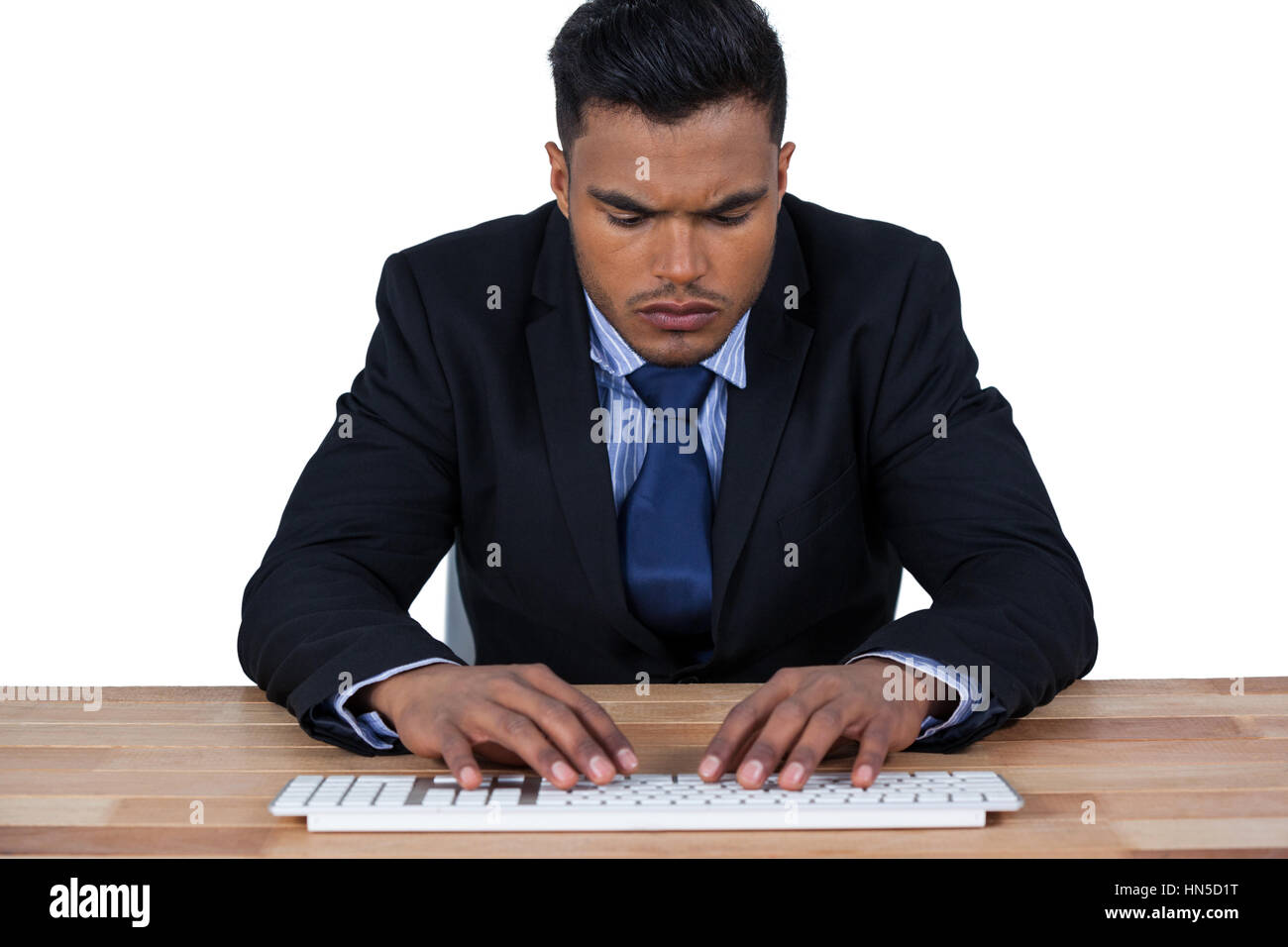 Businessman typing on keyboard at desk against white background Stock ...