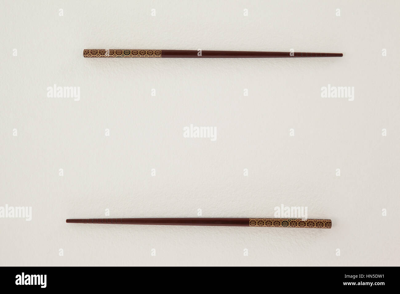 Pair of patterned chopsticks against white background Stock Photo - Alamy