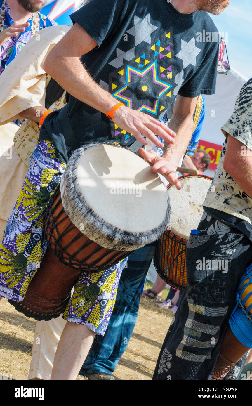 Man playing the djembe during a parade at the Larmer Tree Festival ...