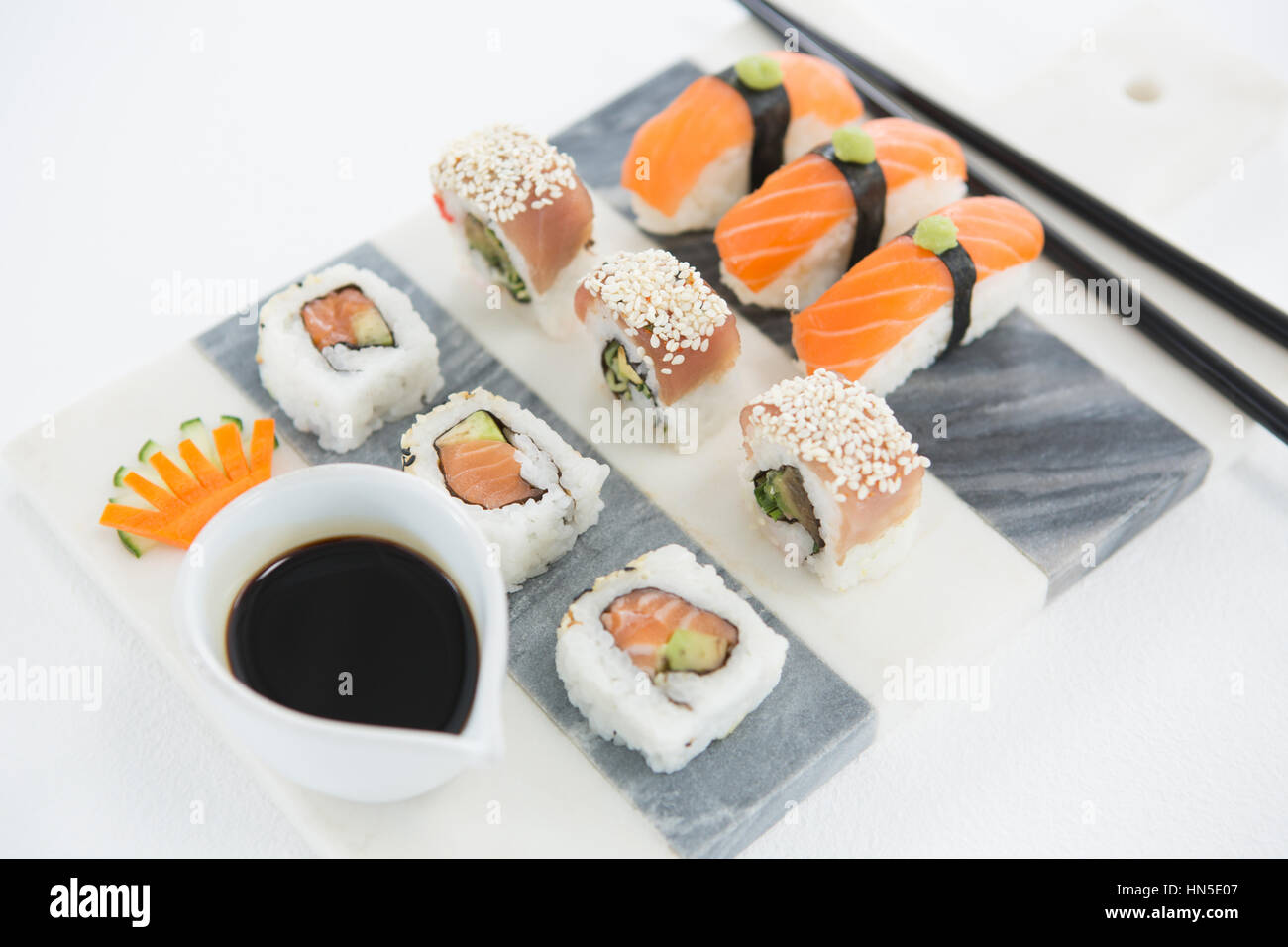 Set of assorted sushi served on gray stone slate against white ...