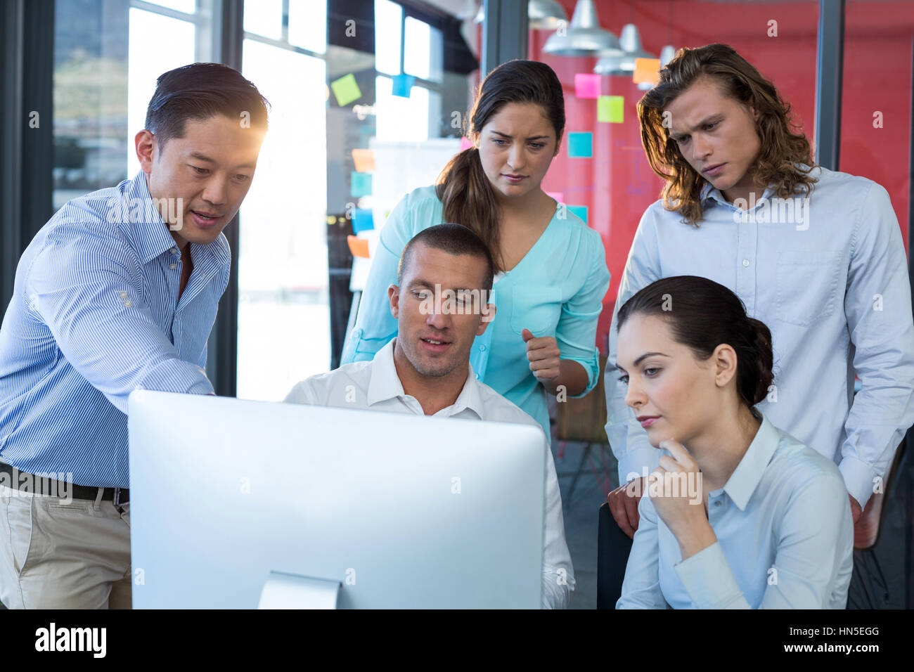 Businesspeople having discussion over personal computer in office Stock ...