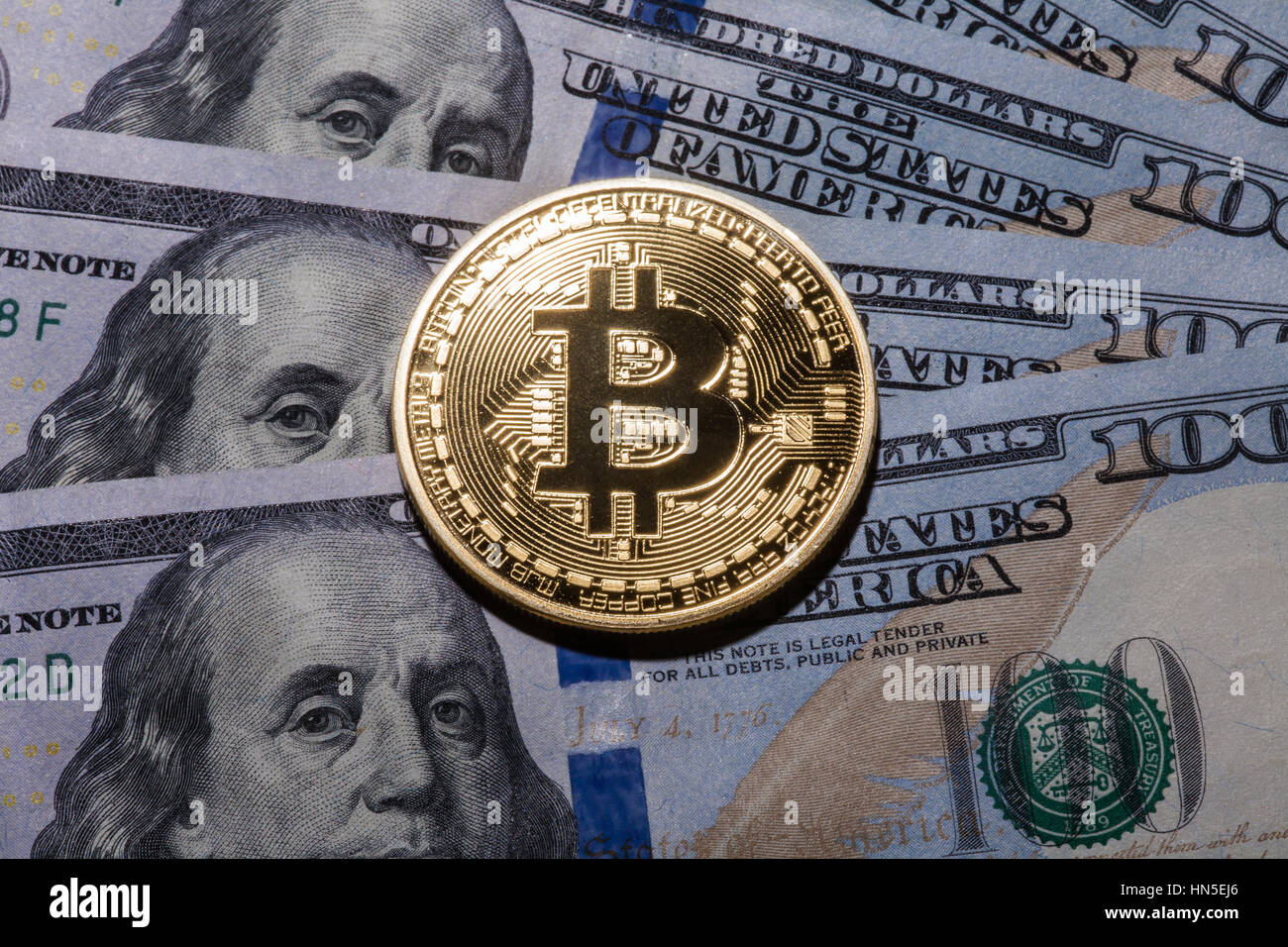 One Bitcoin on hundred dollars bills. Closeup, macro shot Stock Photo ...