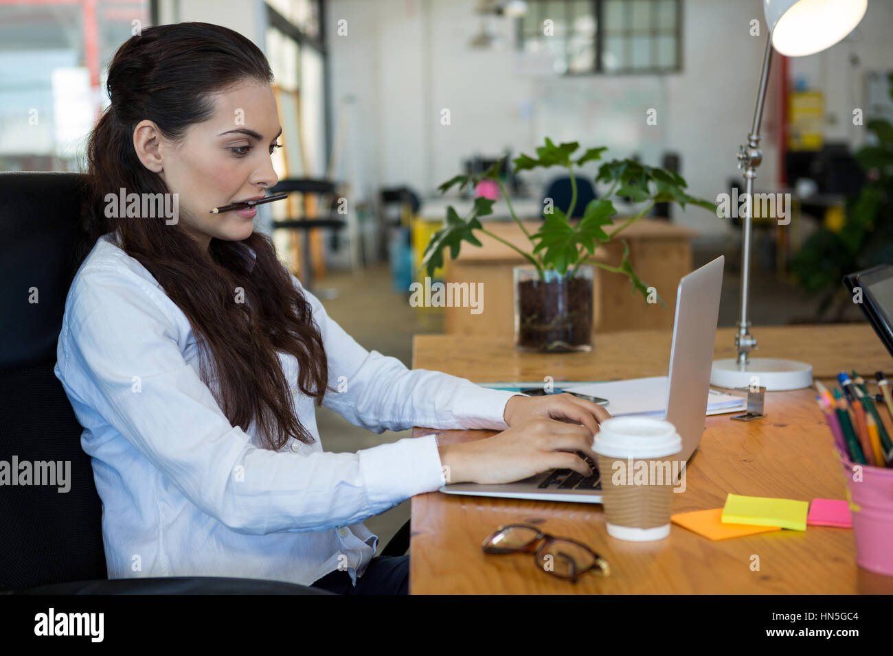 Female business executive using laptop at desk in office Stock Photo ...