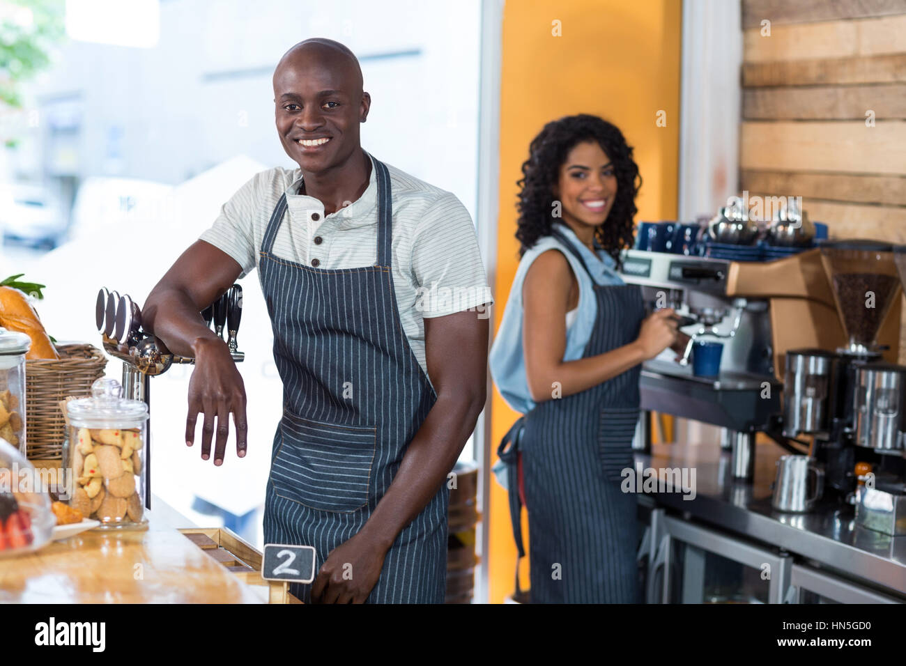 Portrait of smiling waitress and waiter working at counter in cafÃƒÂ ...