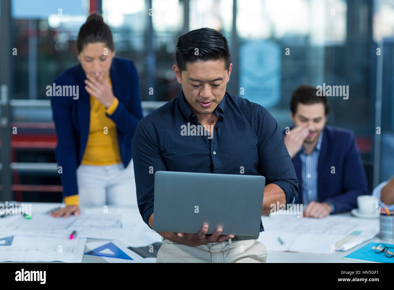 Male business executive using laptop in office Stock Photo - Alamy