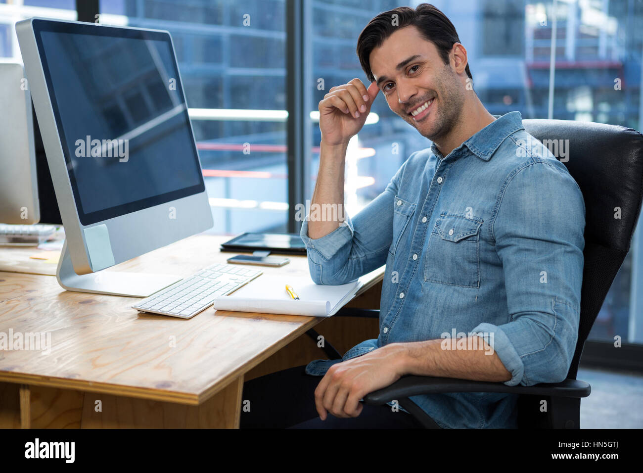 Portrait of happy man sitting at desk in office Stock Photo - Alamy