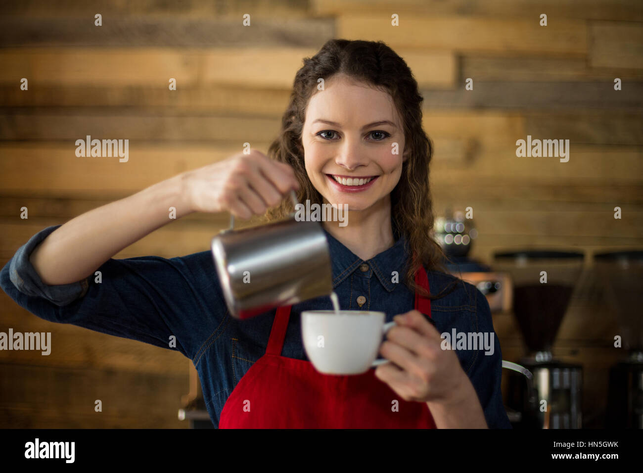 Portrait of smiling waitress making cup of coffee in cafe Stock Photo ...