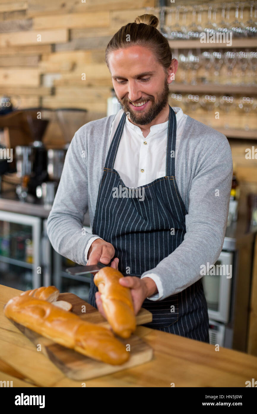 Smiling waiter cutting bread at counter in cafÃƒÂ© Stock Photo - Alamy