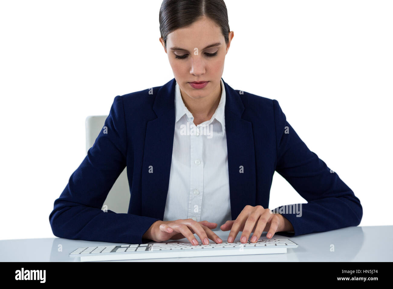 Businesswoman typing on keyboard at desk against white background Stock ...