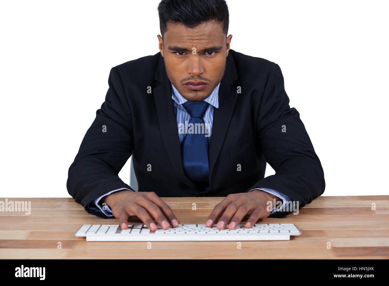 Portrait of businessman typing on keyboard at desk against white ...