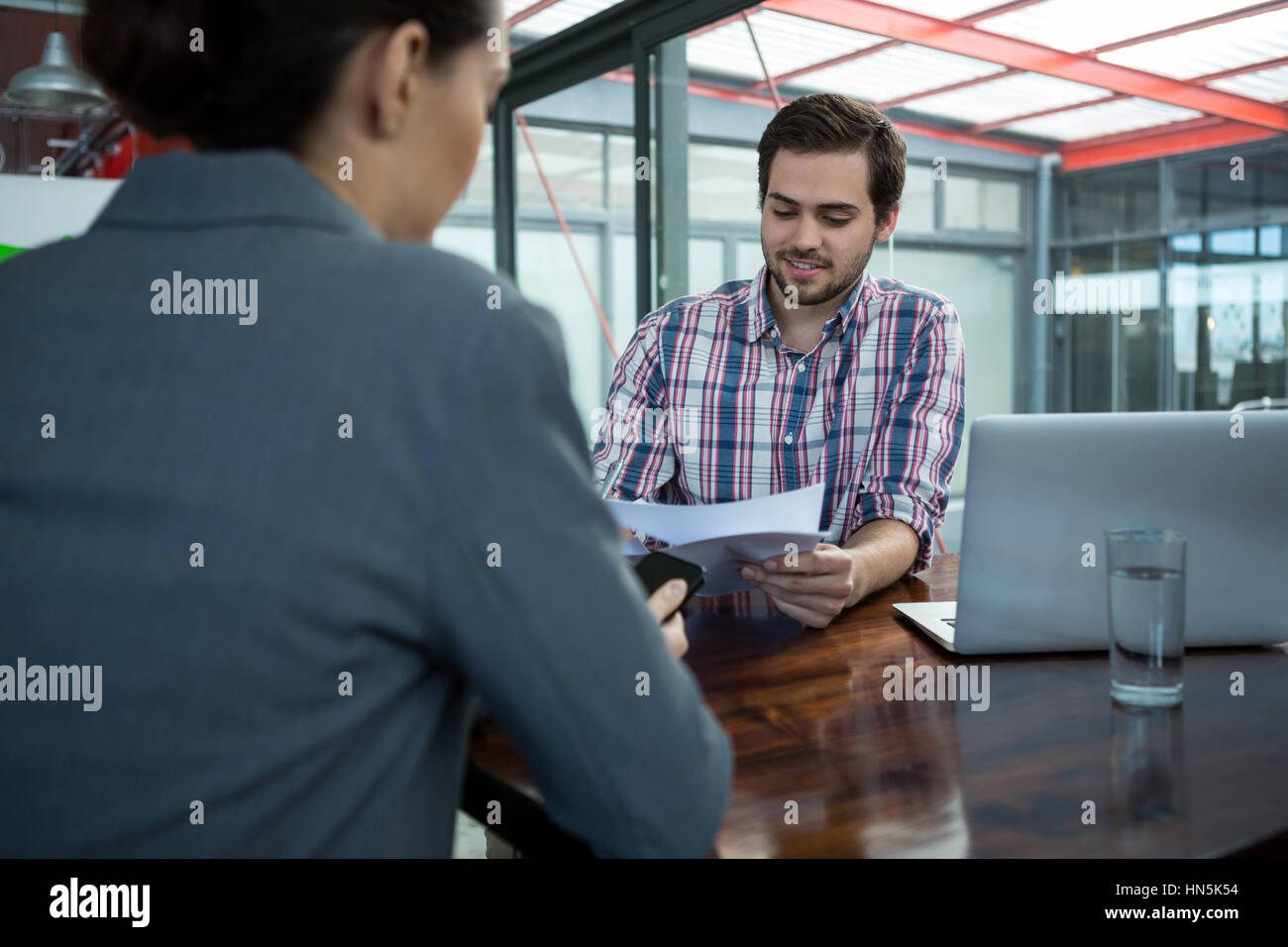 Business executive conducting job interview with woman in office Stock Photo - Alamy