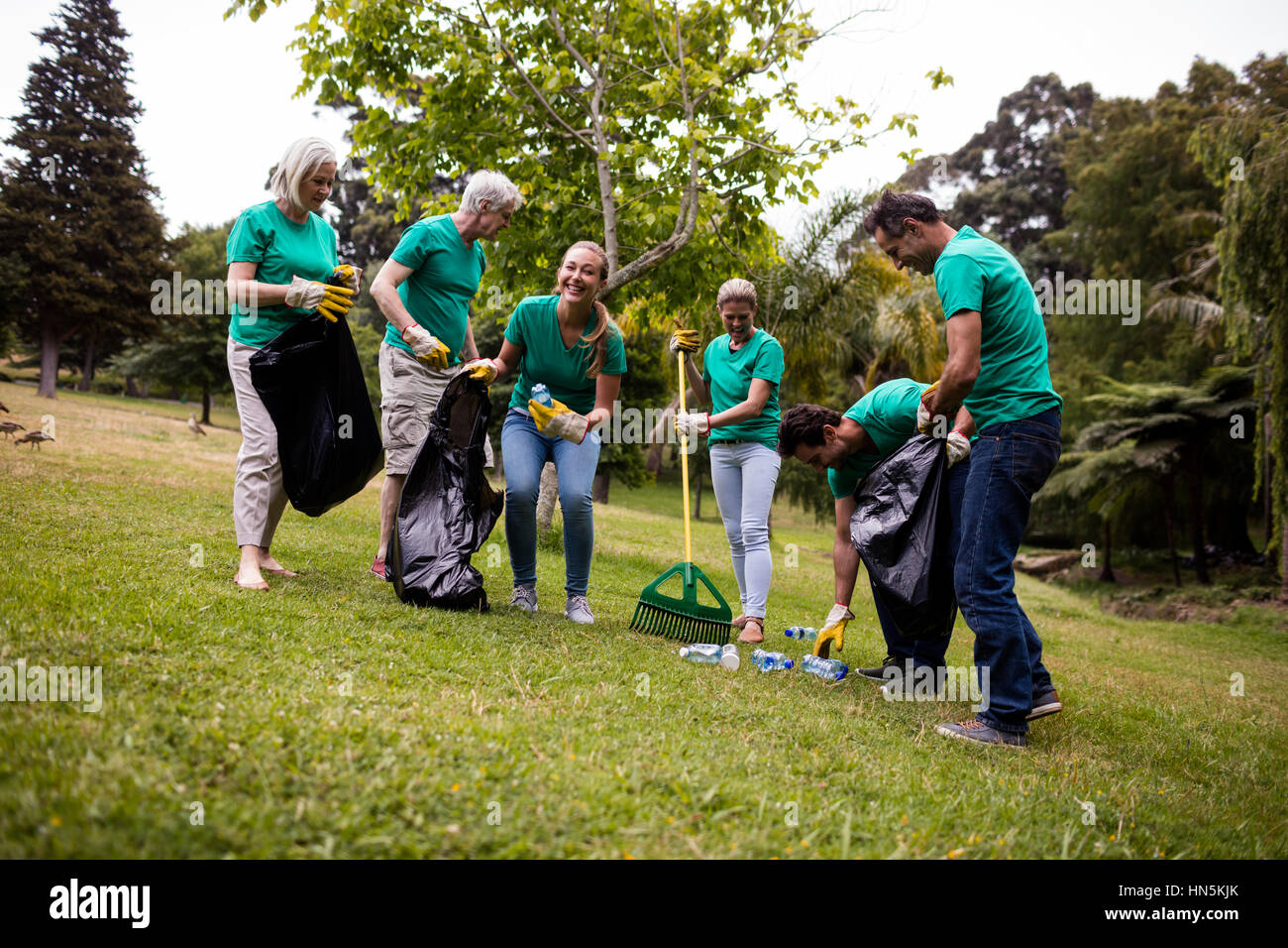 Team of volunteers picking up litter in park Stock Photo - Alamy
