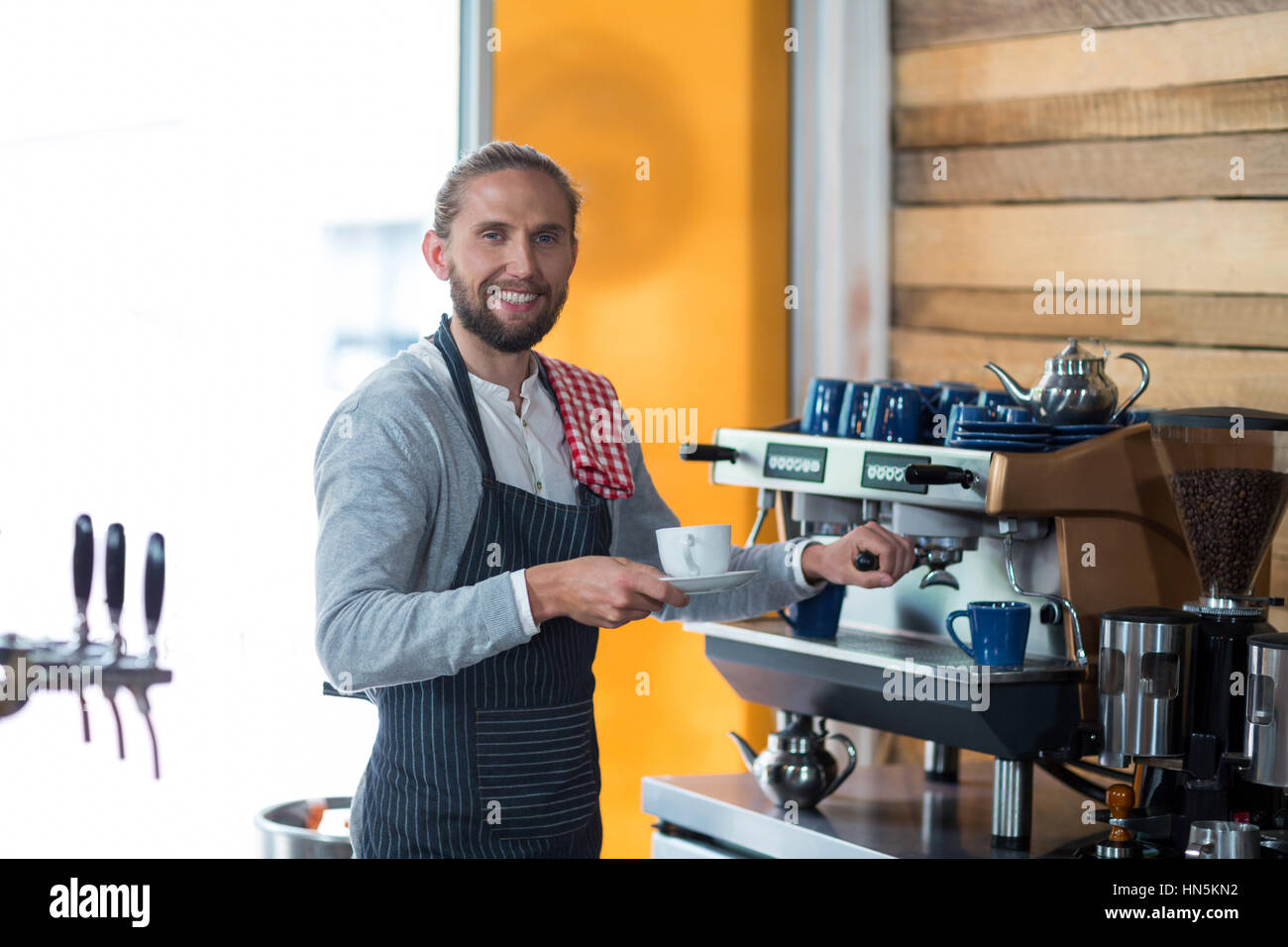 Portrait of smiling waiter making cup of coffee in cafe Stock Photo - Alamy
