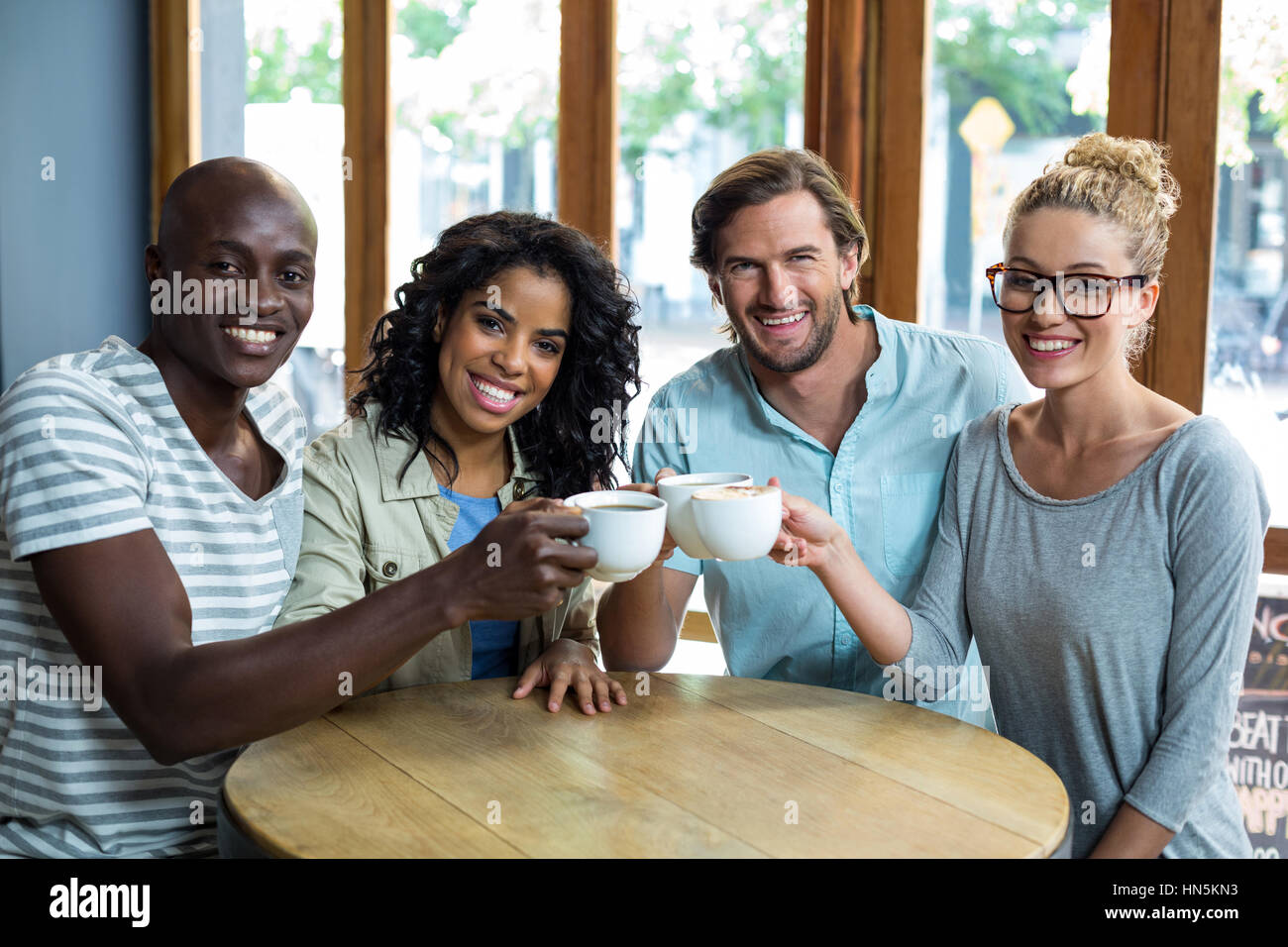 Portrait of happy friends toasting cup of coffee in cafÃƒÂ© Stock Photo ...