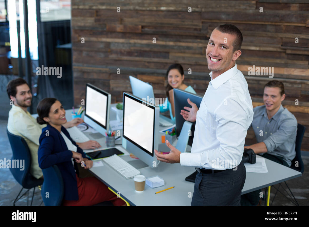 Graphic designers interacting while working on personal computer in ...