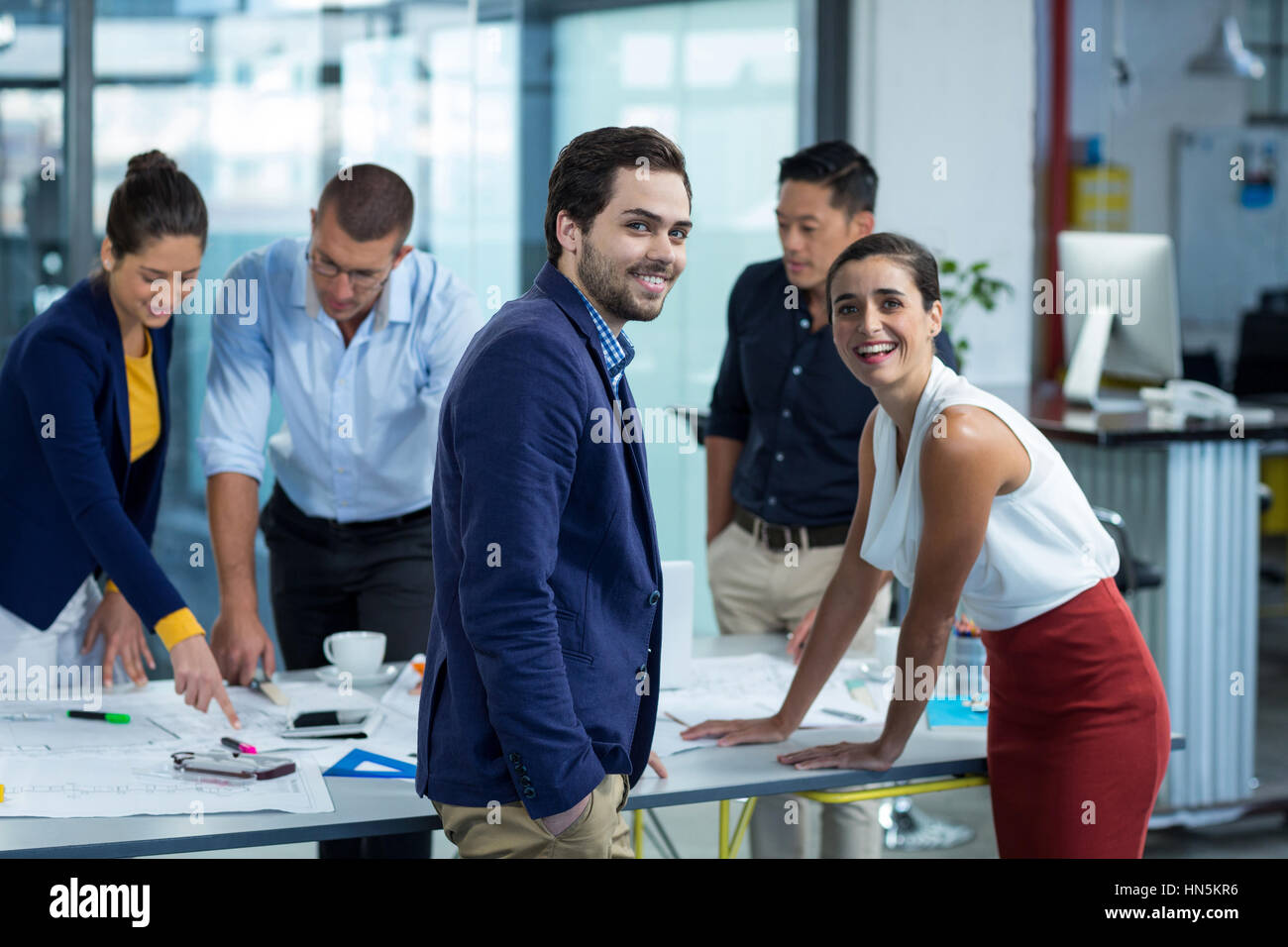Smiling business executives discussing during meeting in office Stock ...