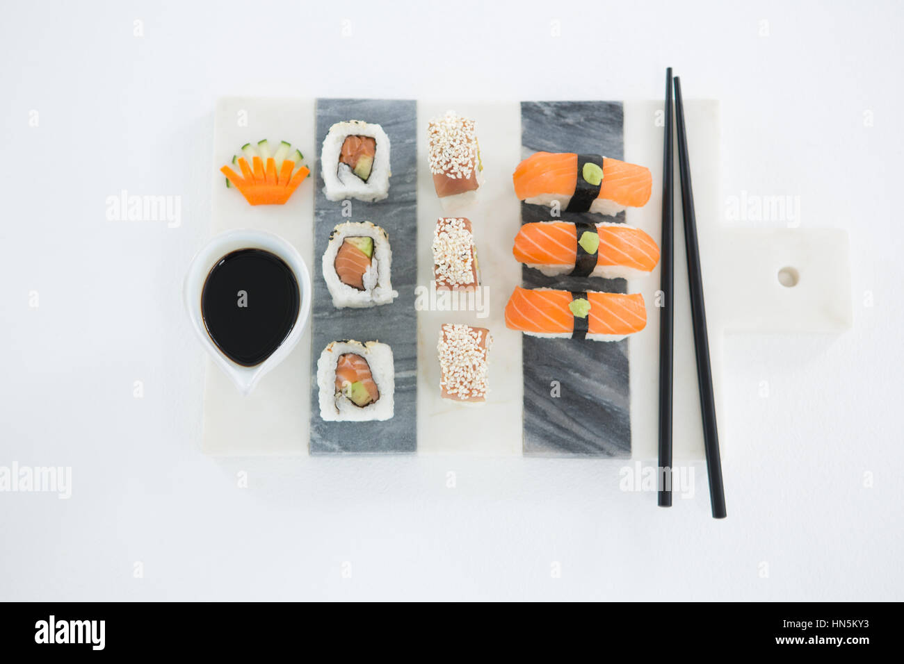 Set of assorted sushi served on gray stone slate against white ...