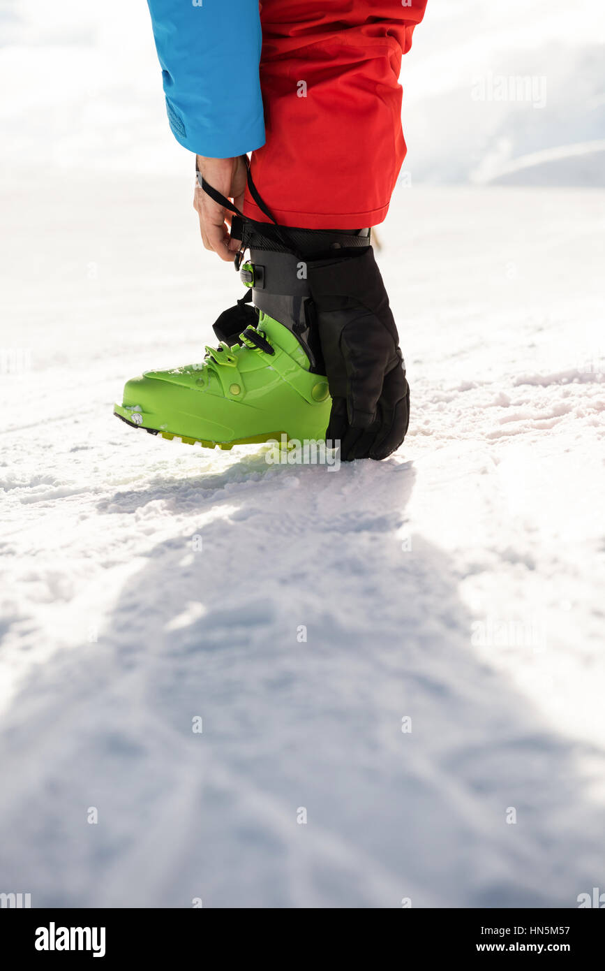 Low section of skier tying his boot strap Stock Photo - Alamy