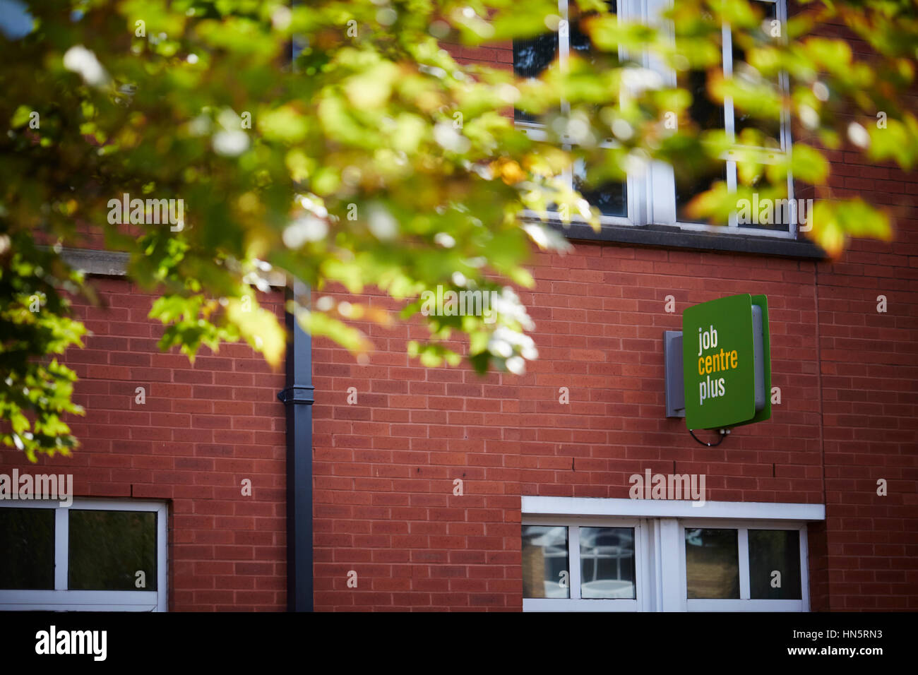 Green sign on the exterior architecture wall of Job Centre Plus doorway ...