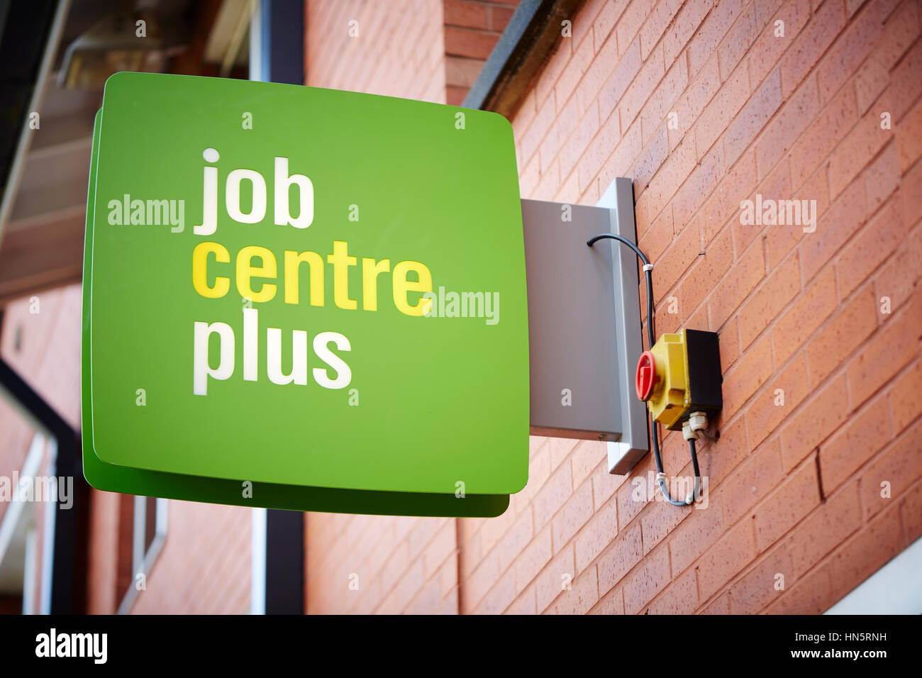 Green sign on the exterior architecture wall of Job Centre Plus doorway ...