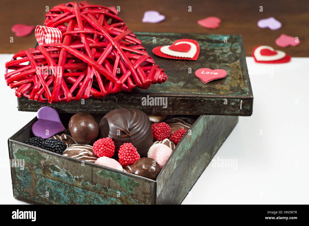 Sweets and decorative Valentine's Day heart in an old box. Close-up ...